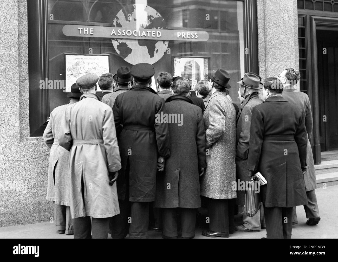 Londoners crowd round the window of the Associated Press bureau in ...