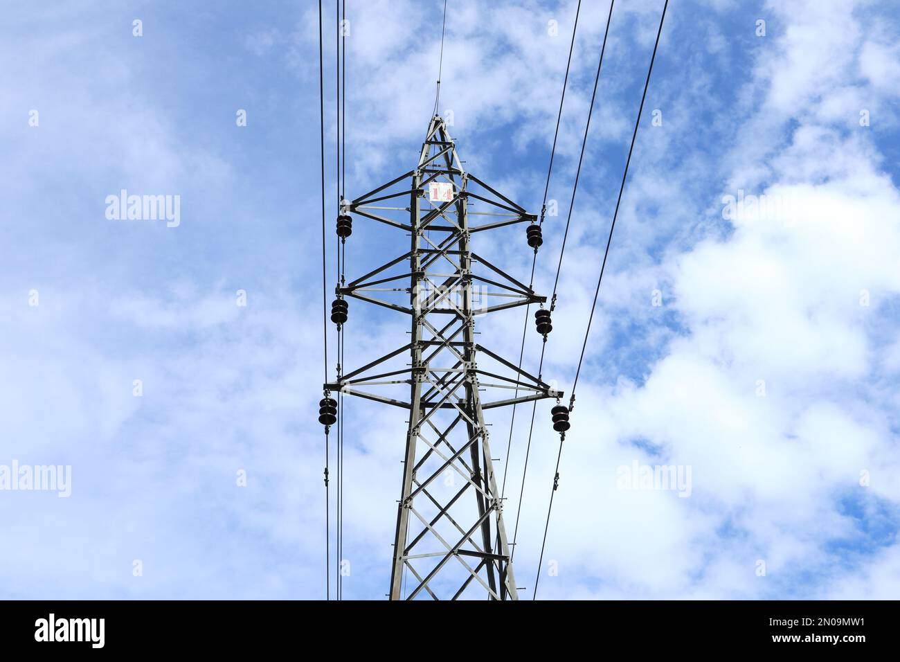 Low angle view of a high voltage electrical tower under the blue sky ...