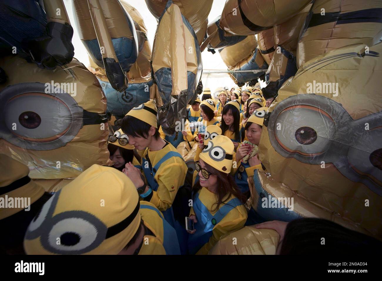 Participants dressed as "minions" walk through the balloon depicting ...