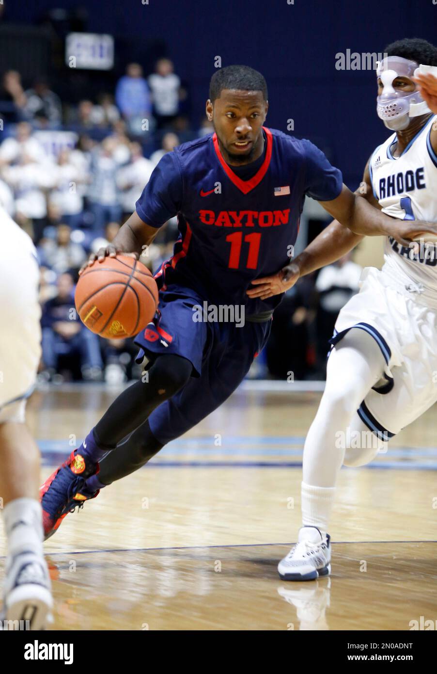 Dayton's Scoochie Smith (11) drives past Rhode Island's Jarvis Garrett ...