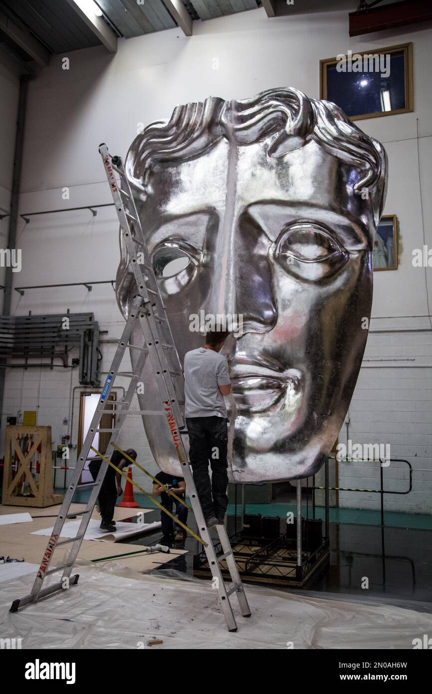 A set builder works on a giant replica of the British Academy Films ...