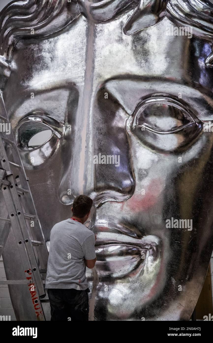 A set builder works on a giant replica of the British Academy Films ...
