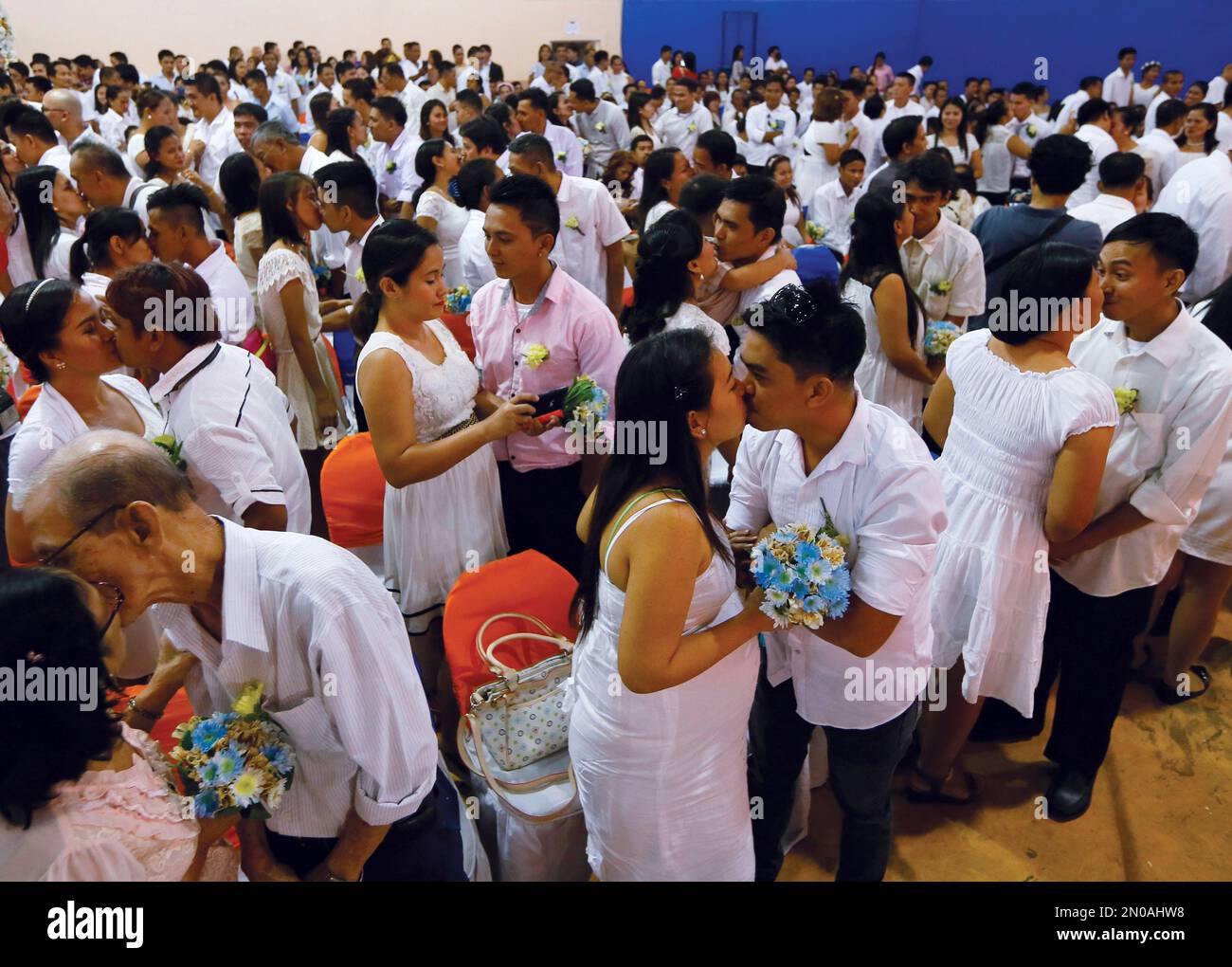 Filipino couples kiss during a mass wedding ahead of Sunday's Valentine ...