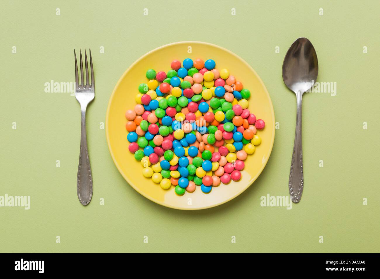 cutlery on table and sweet plate of candy. Health and obesity concept ...