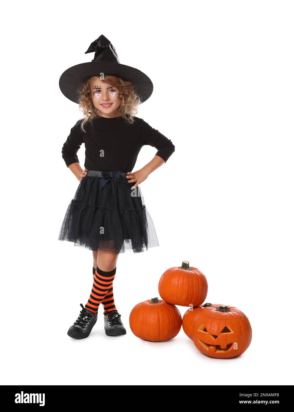 Cute little girl wearing Halloween costume and pumpkins on white ...