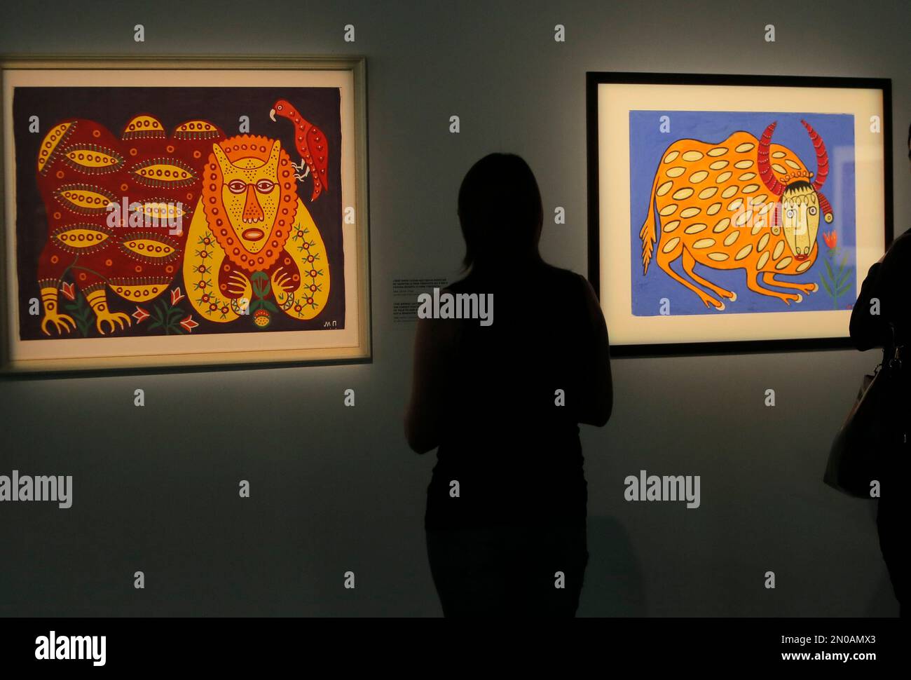 A visitor looks at paintings by Maria Primachenko, a renowned Ukrainian ...