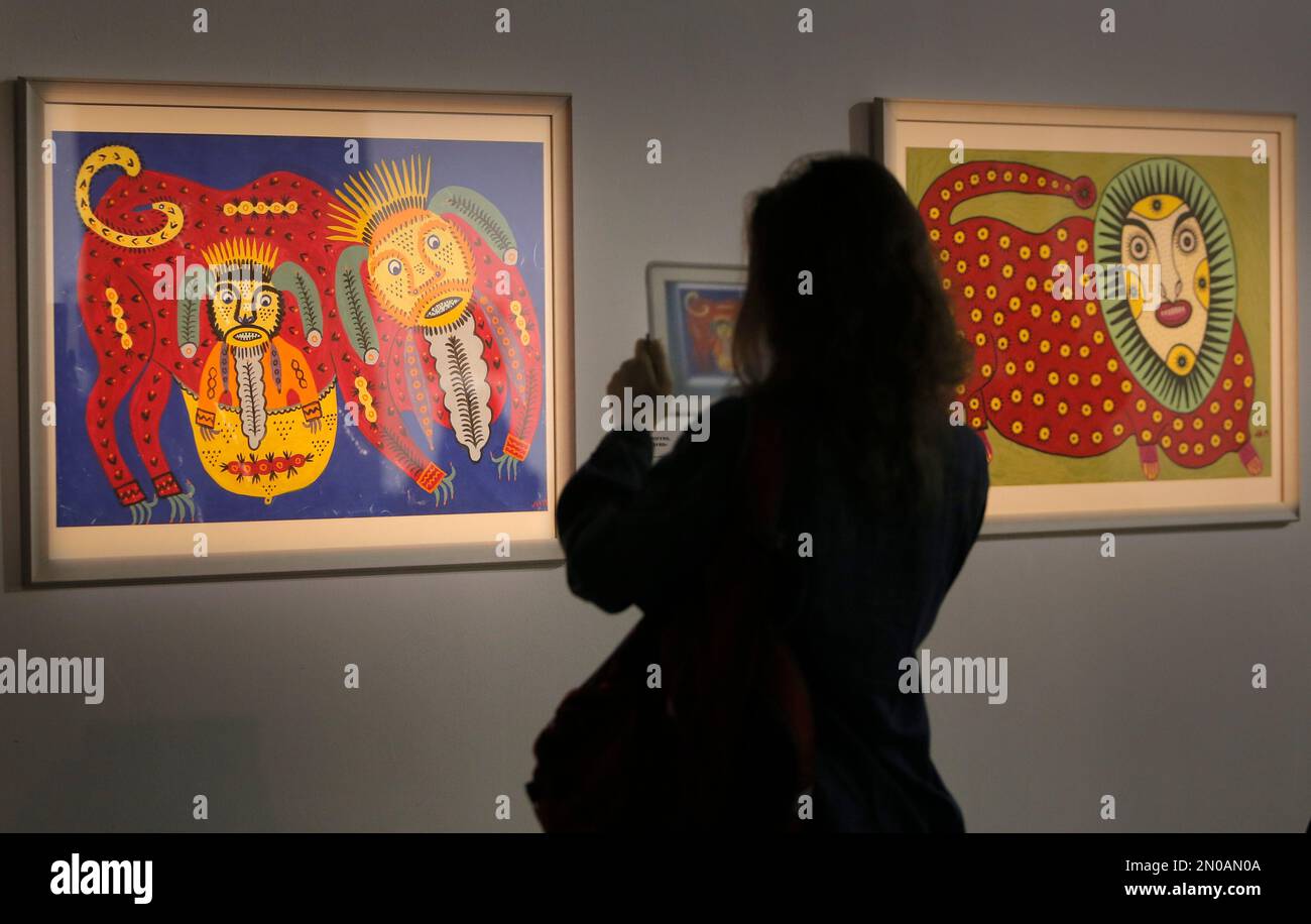 A visitor takes photo of painting by Maria Primachenko, a renowned ...