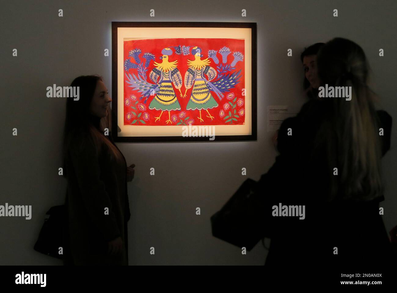 Visitors look at a painting by Maria Primachenko, a renowned Ukrainian ...