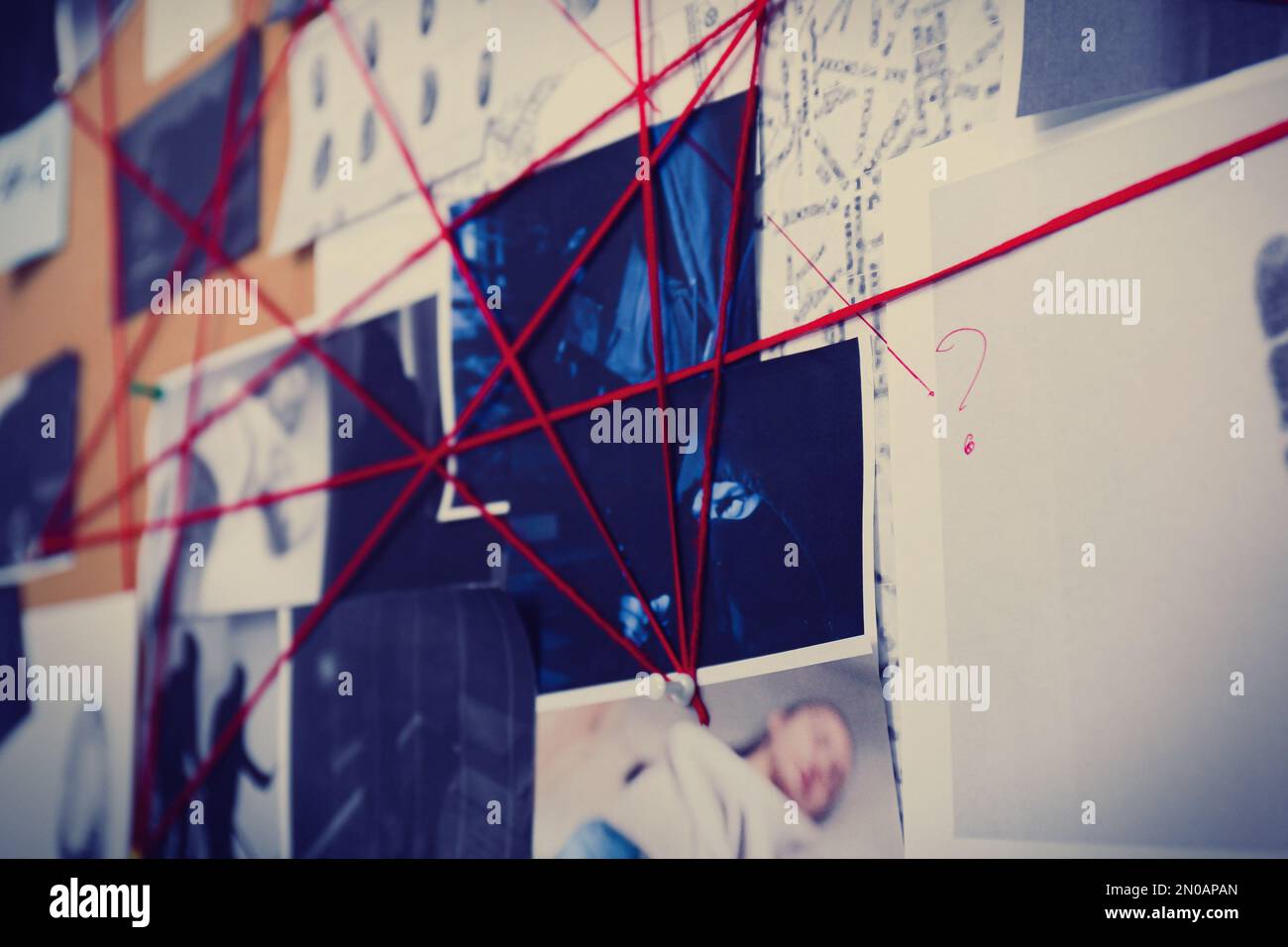Detective board with crime scene photos and red threads, closeup Stock ...