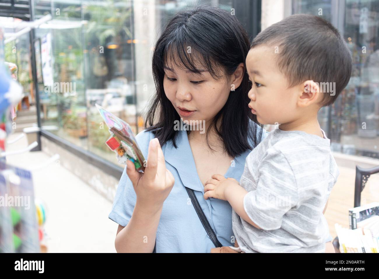 Mother holding the little boy pick goods Stock Photo - Alamy