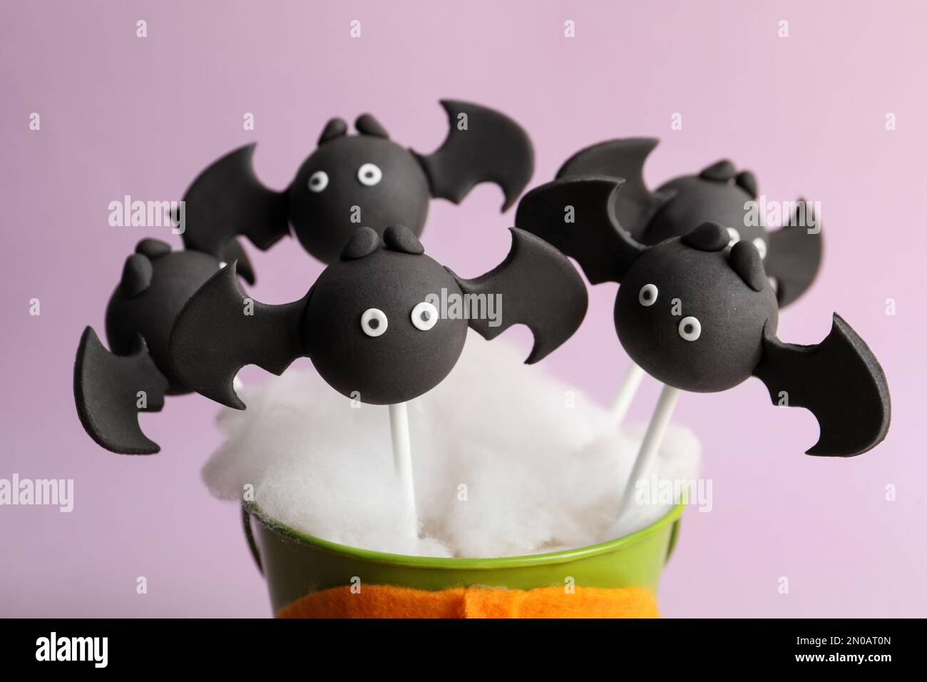 Delicious bat shaped cake pops on pink background, closeup. Halloween ...