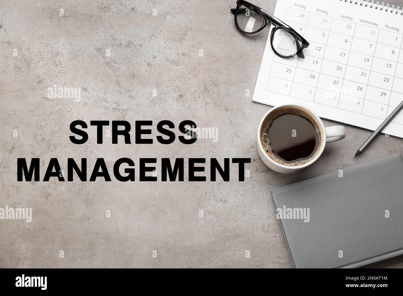 Text Stress Management on grey table with calendar, stationery ...