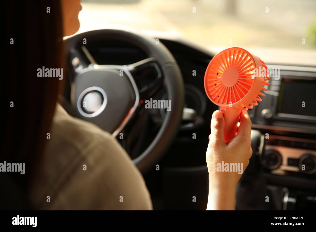 Woman with portable fan in car on hot summer day, closeup Stock Photo ...