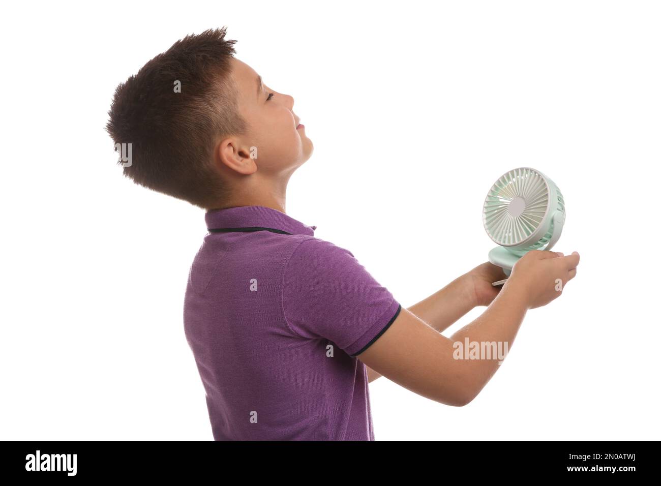 Little boy enjoying air flow from portable fan on white background ...