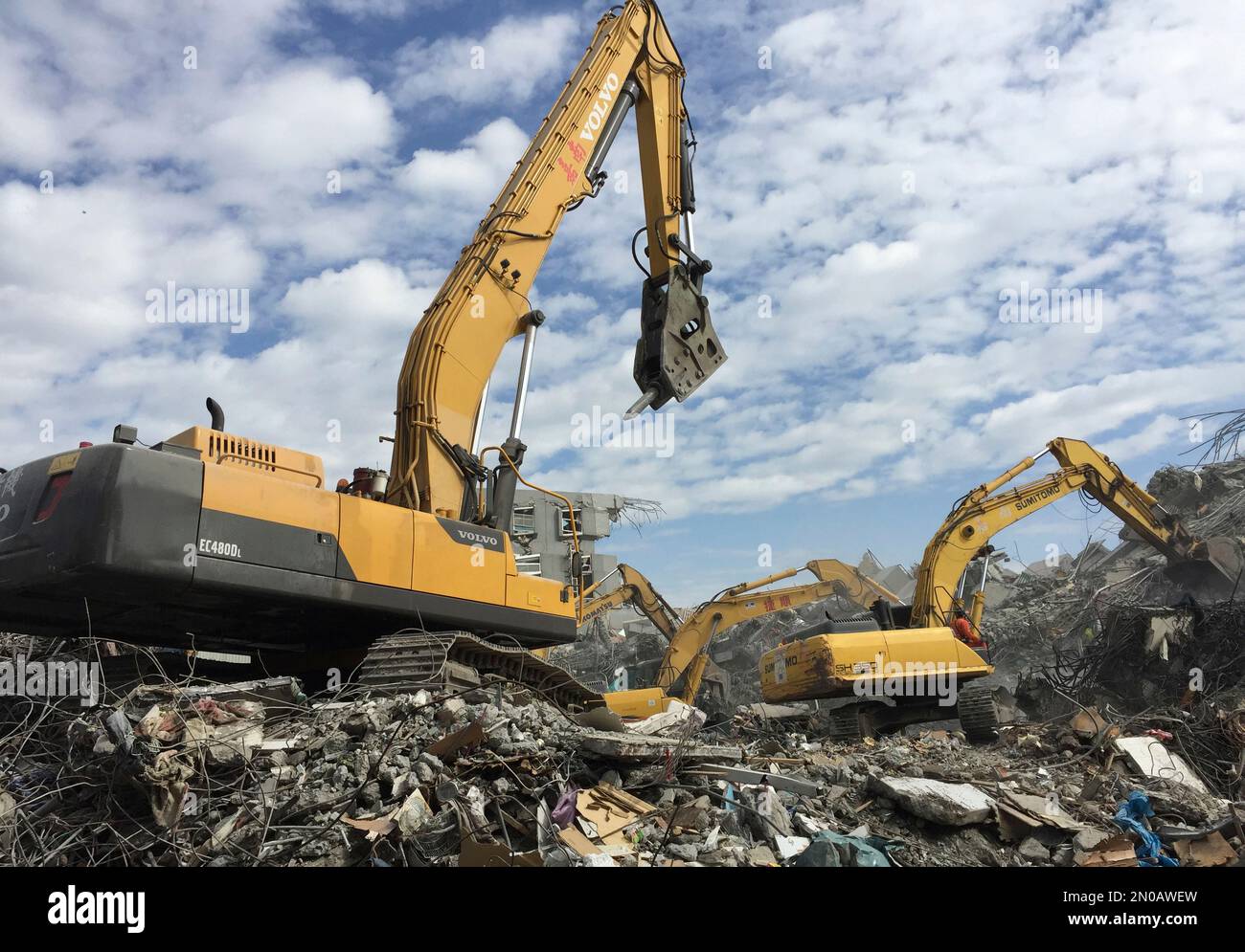 Rescue teams continue to use heavy excavation machinery to dig through ...