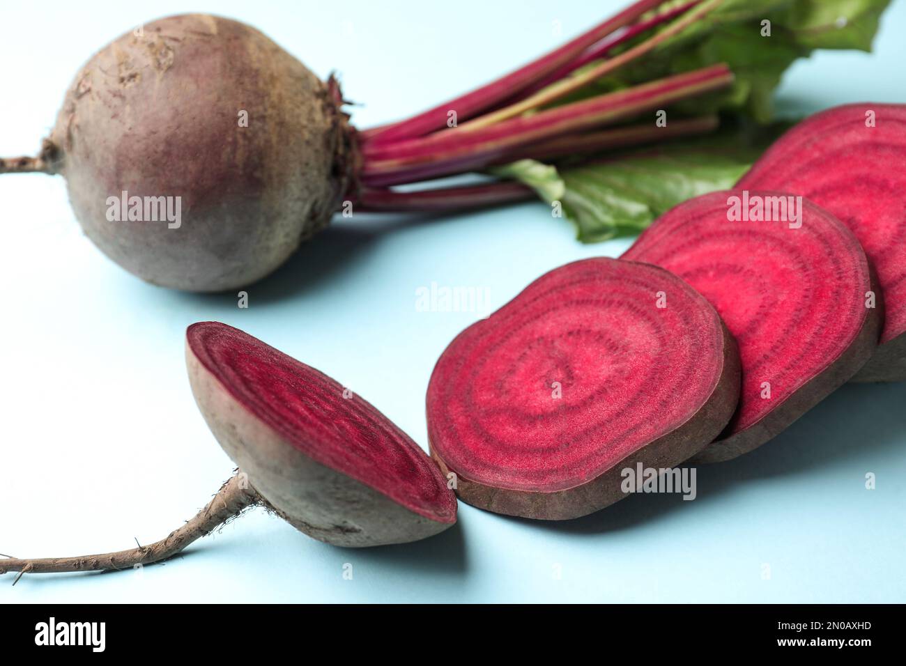 Whole and cut fresh red beets on light blue background, closeup Stock ...