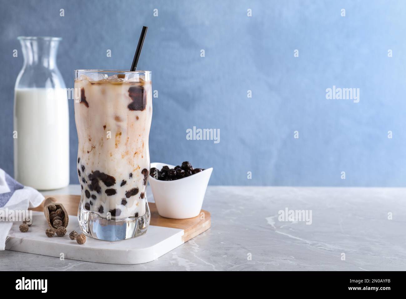 Bubble milk tea with tapioca balls on grey marble table against blue ...