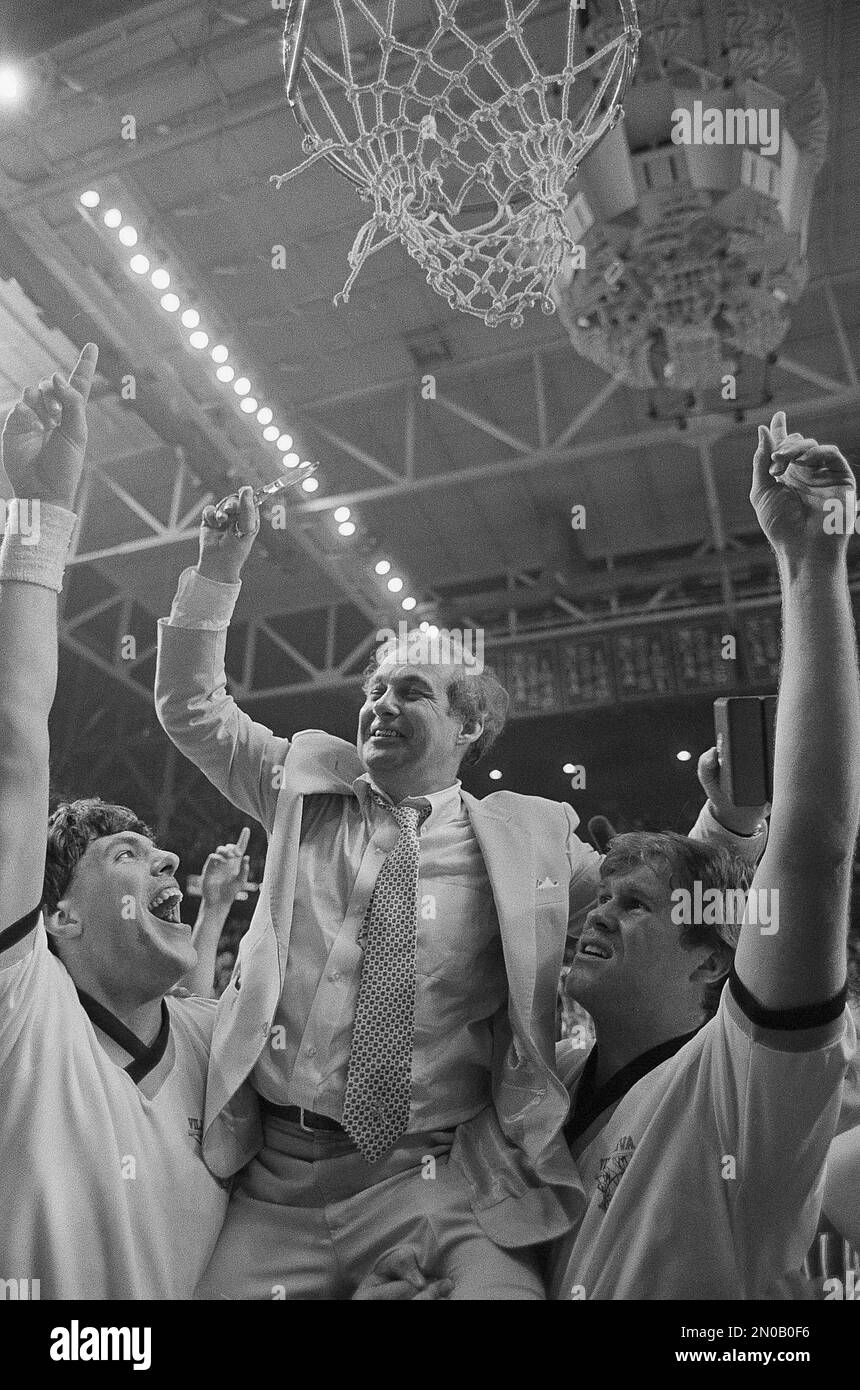 Villanova coach Rollie Massimino, scissors in hand, is boosted aloft to ...