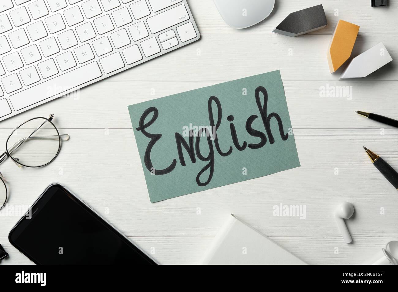 Sheet of paper with word ENGLISH, keyboard, smartphone and stationery ...