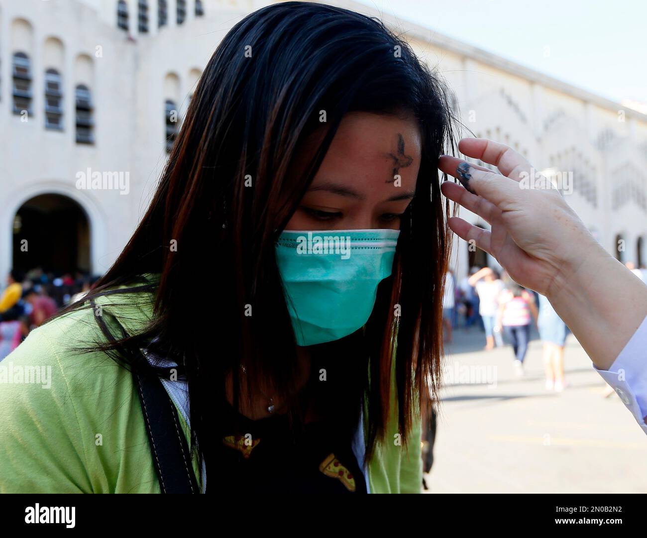 A Roman Catholic nun marks a sign of the cross on the forehead of a ...