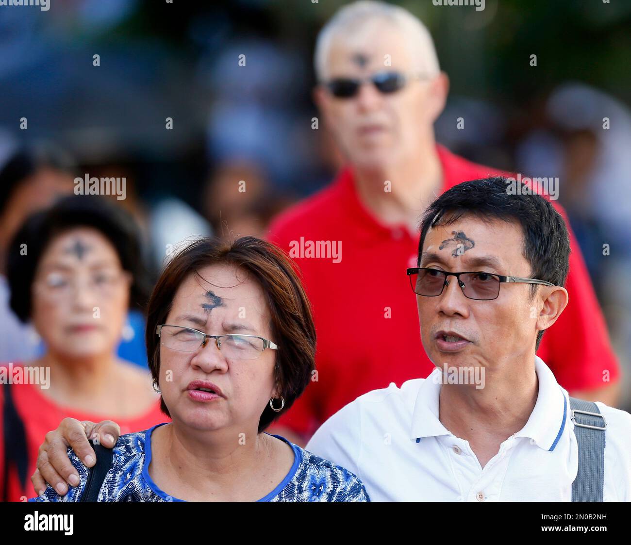 Roman Catholic devotees have their foreheads marked with a sign of the ...
