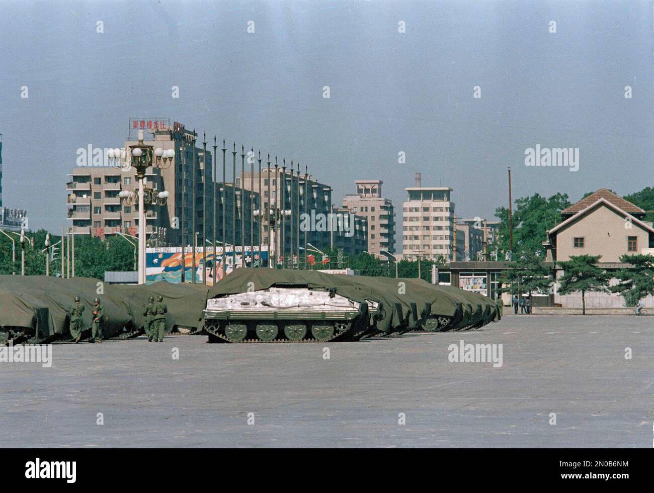 Chinese soldiers walk through two rows of armored personnel carriers ...