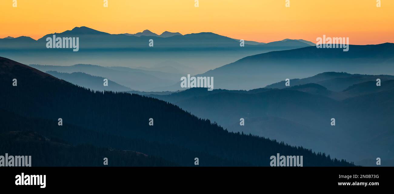 Mountain sunset header. Foggy valleys and blue mountain contours ...