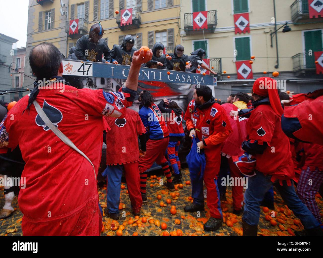 Costumed revelers throw oranges during Carnival in the northern Italian ...