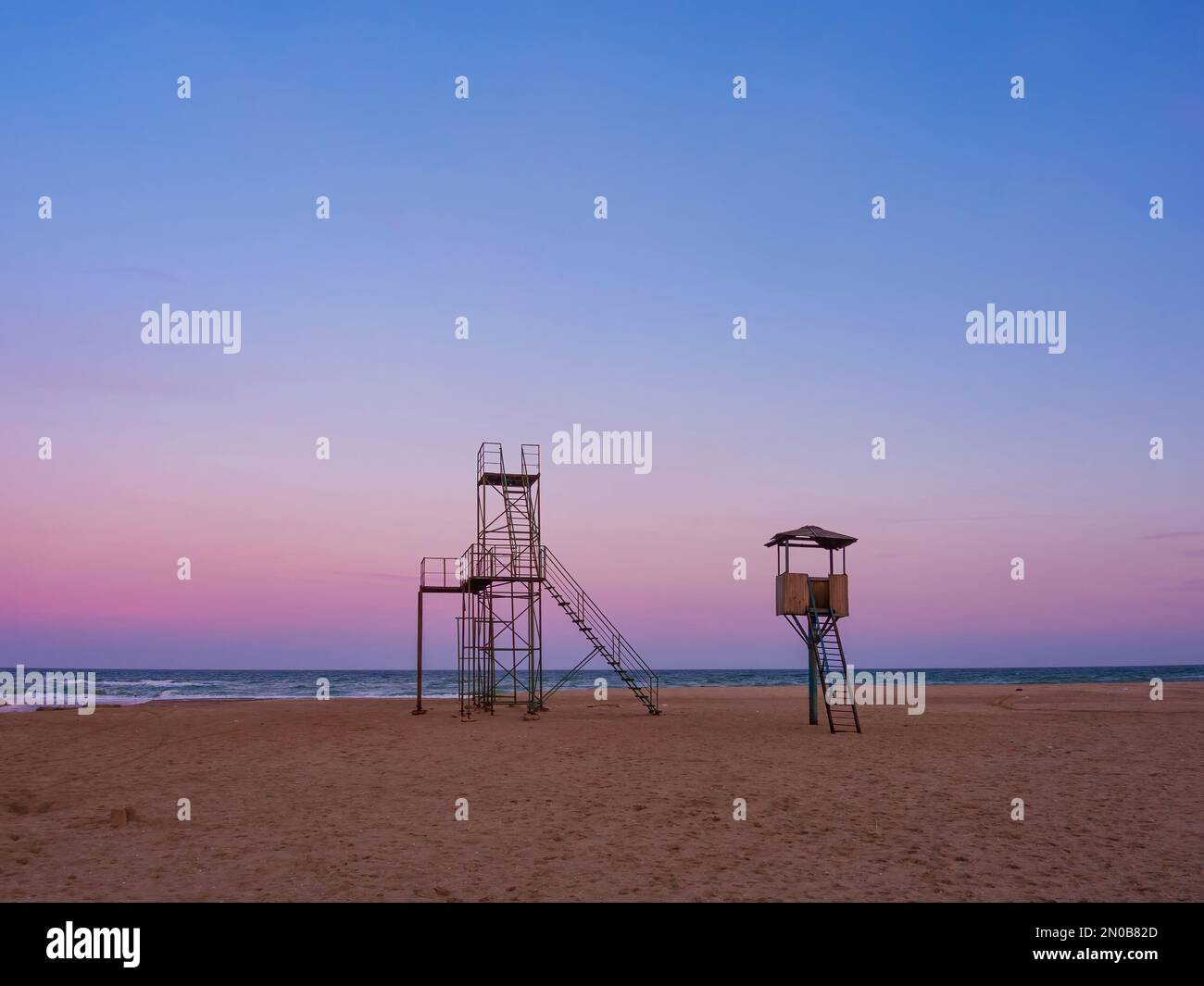 Empty sand beach at the sunset. Rescue tower and beach attractions at ...