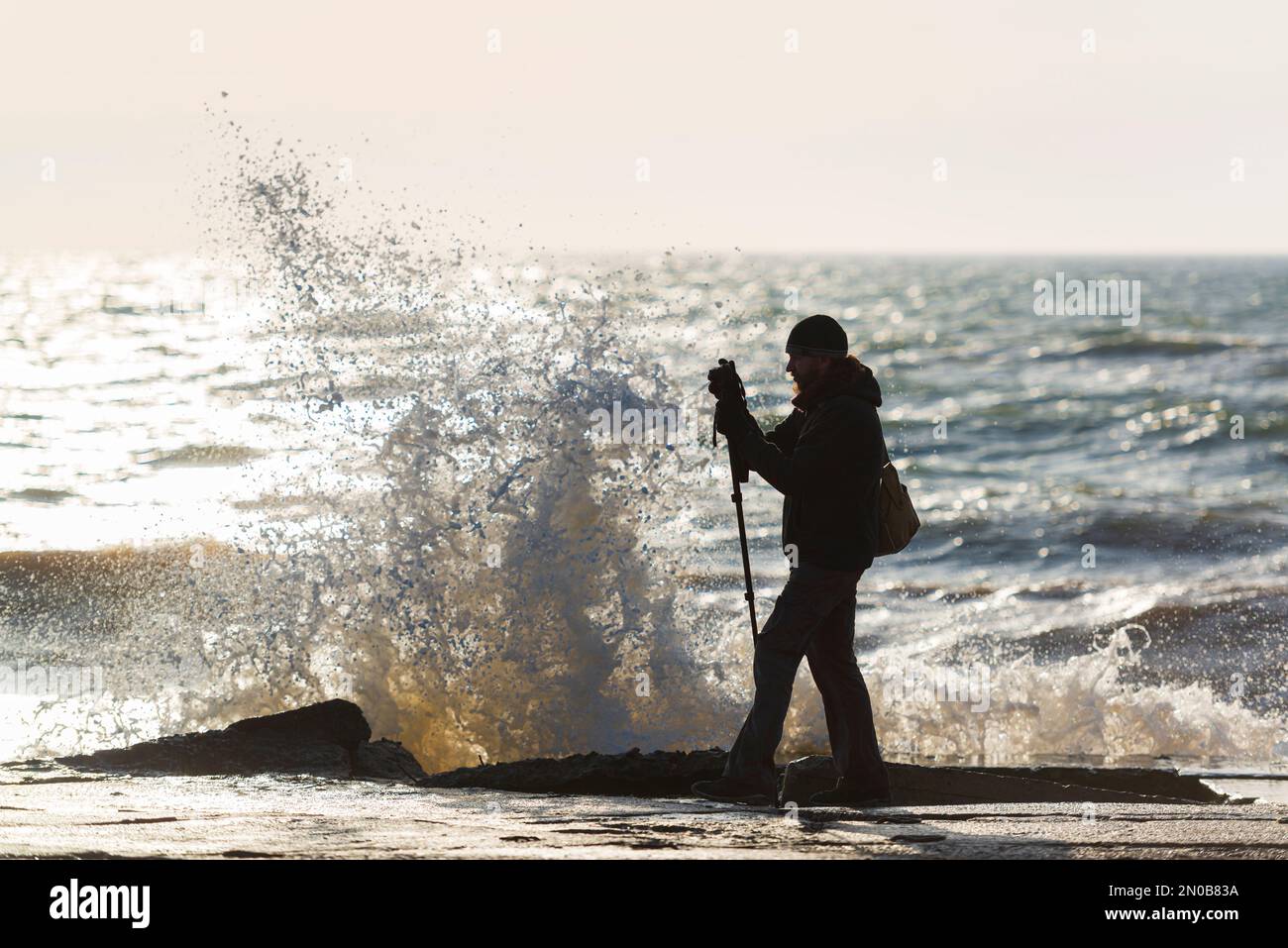 Photographer silhouette at the seaside. Professional photographer takes ...