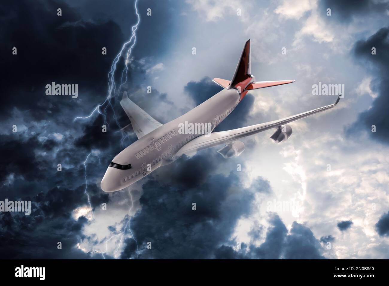 Airplane flying in cloudy sky during thunderstorm Stock Photo - Alamy