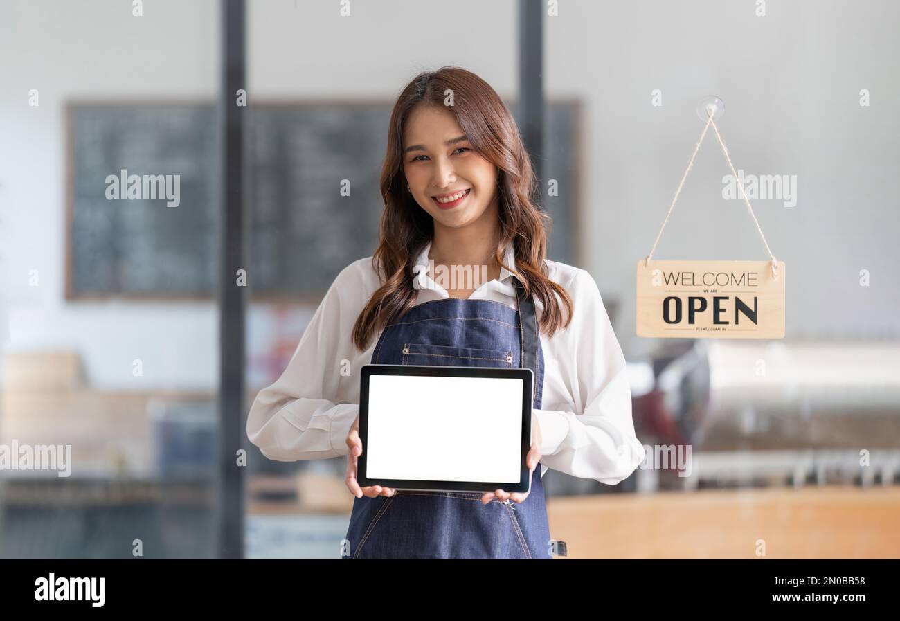 portrait of a woman wearing an apron holding a digital tablet with a ...
