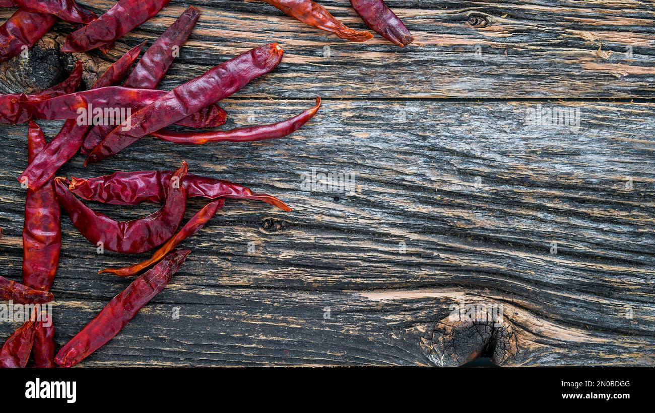 Dry sicy red pepper on rustic wooden background from above with copy ...
