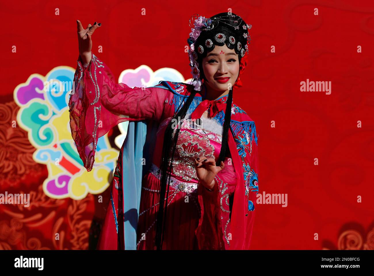 A Chinese performer dressed in traditional costume performs a cultural ...