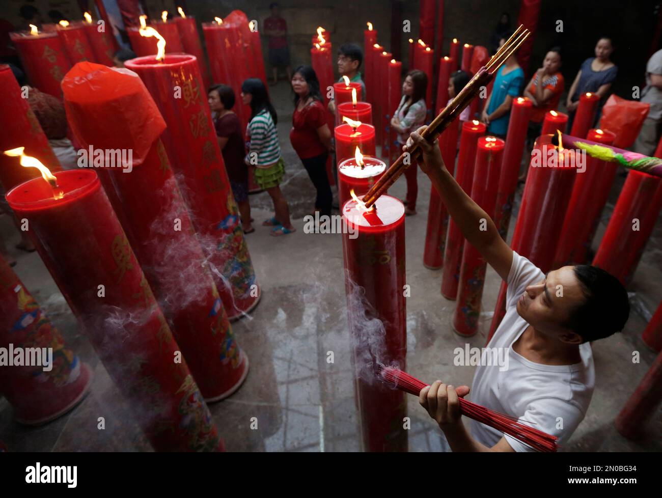 An Indonesian ethnic Chinese man lights incense sticks during the ...
