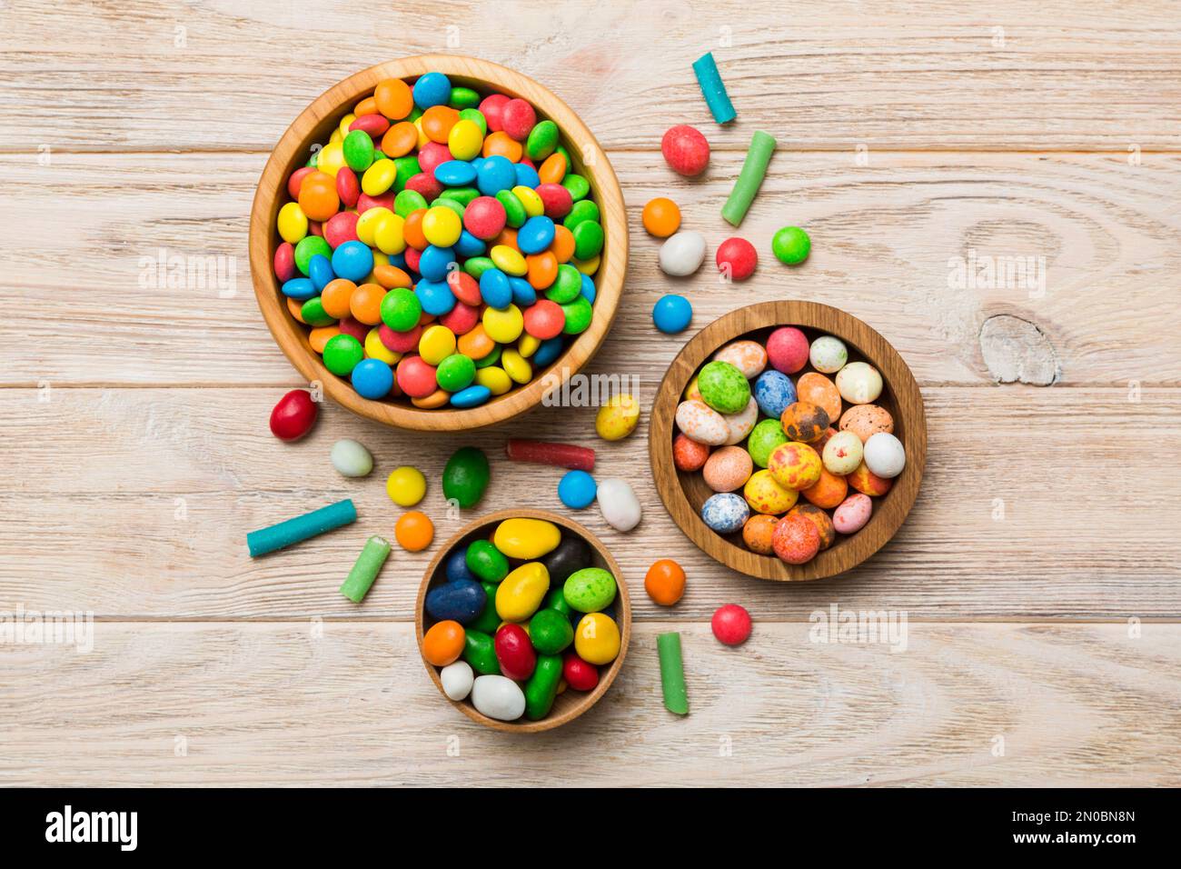 different colored round candy in bowl and jars. Top view of large ...