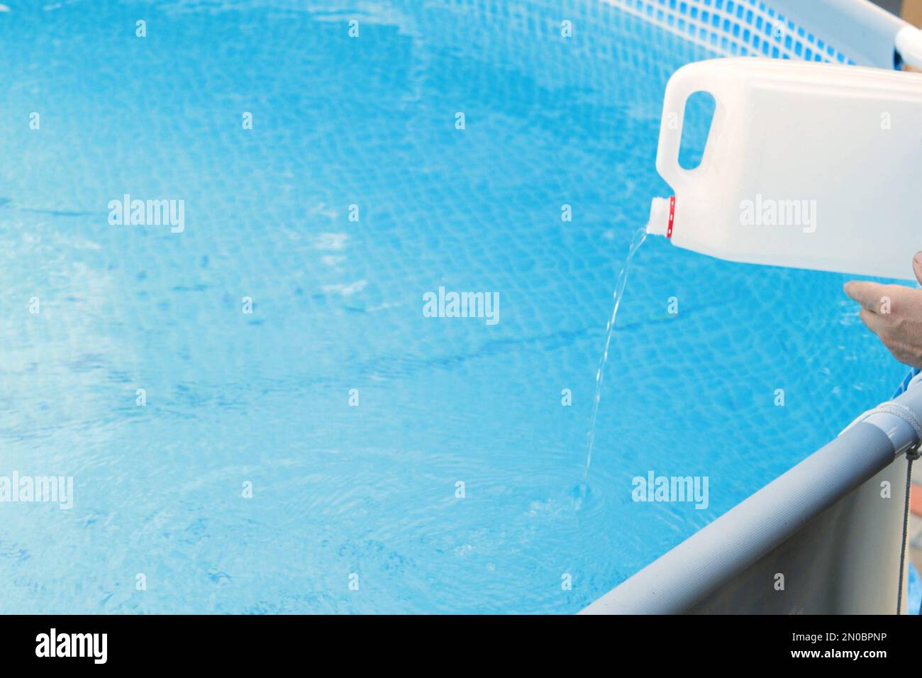 Cleaning a PVC frame pool from algae by pouring perhydrol, Concept of ...