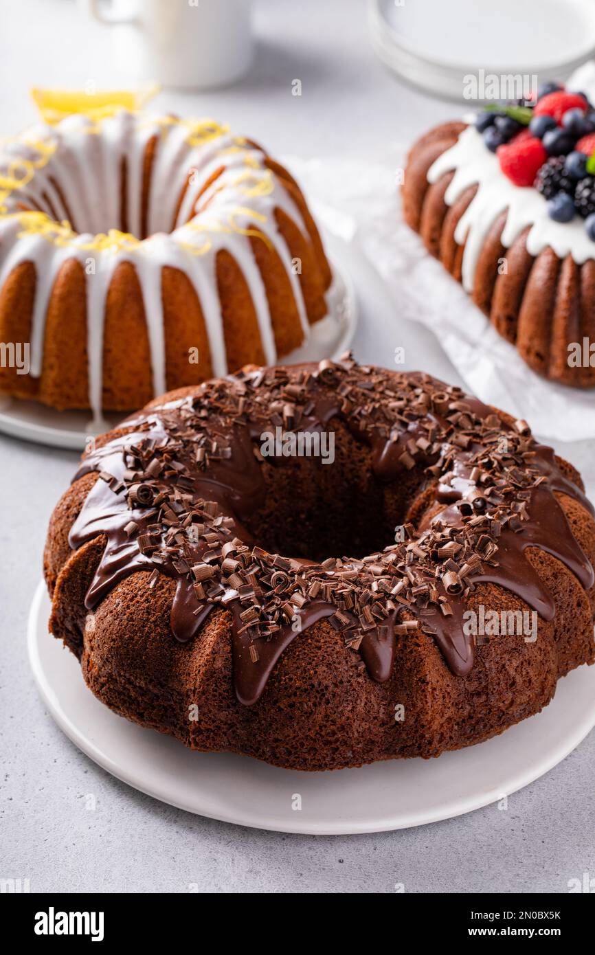 Variety of bundt cakes on the table with lemon, chocolate and berry ...