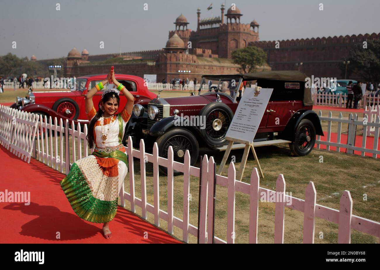 An Indian dancer poses in front of Rolls Royce vintage cars displayed ...