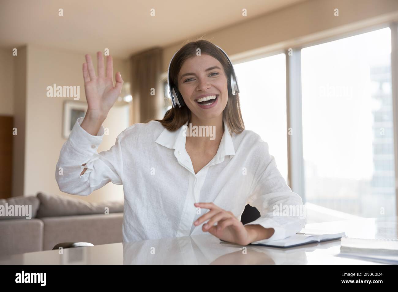Happy gadget user girl in big earphones waving greeting hand Stock ...