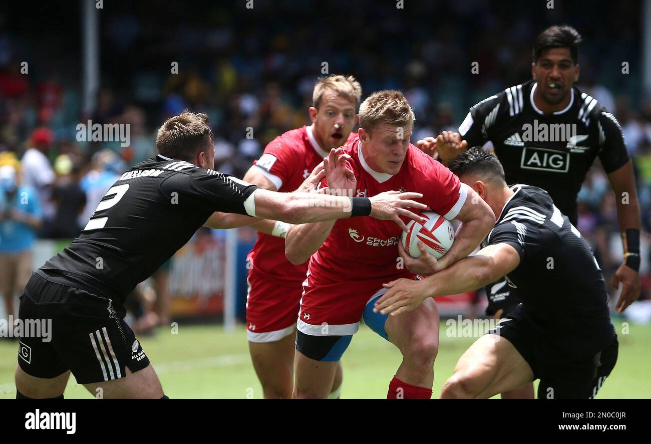 John Moonlight of Canada, center, is tackled by New Zealand's Tim ...