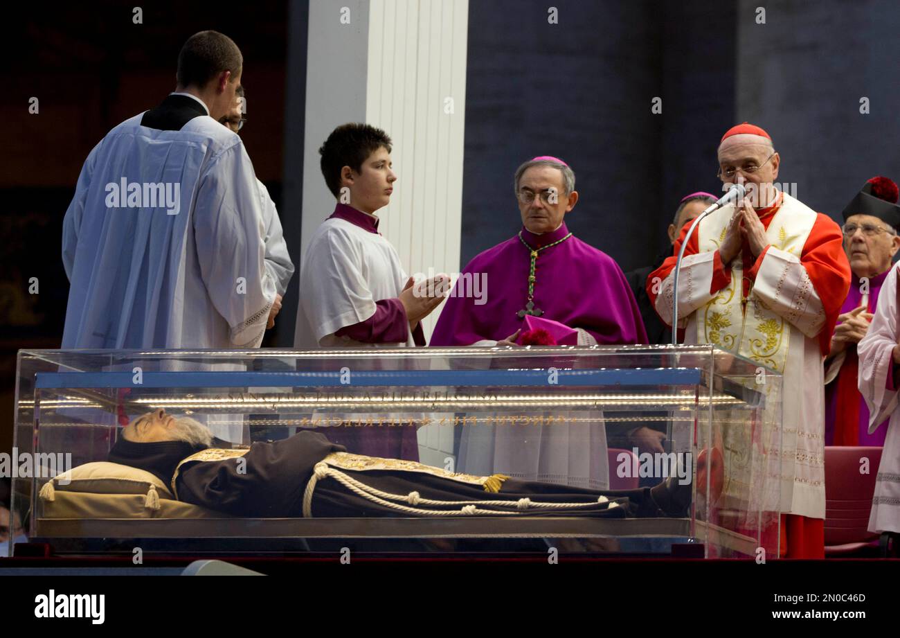 Cardinal Angelo Comastri, right, prays in front of the box containing ...