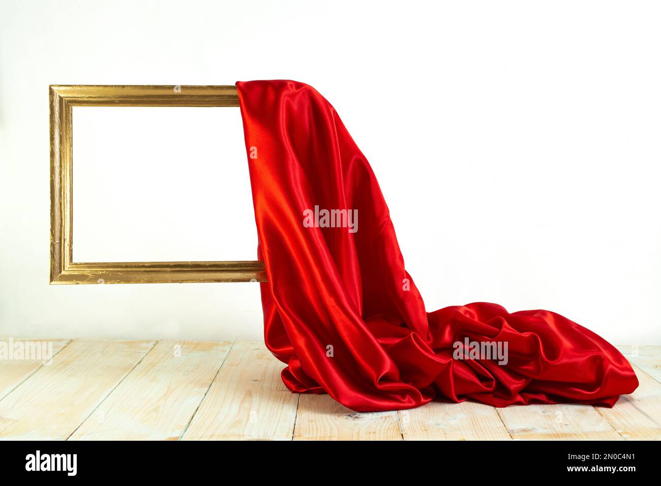 red satin cloth unveiling a golden frame. Levitating frame, mockup for ...