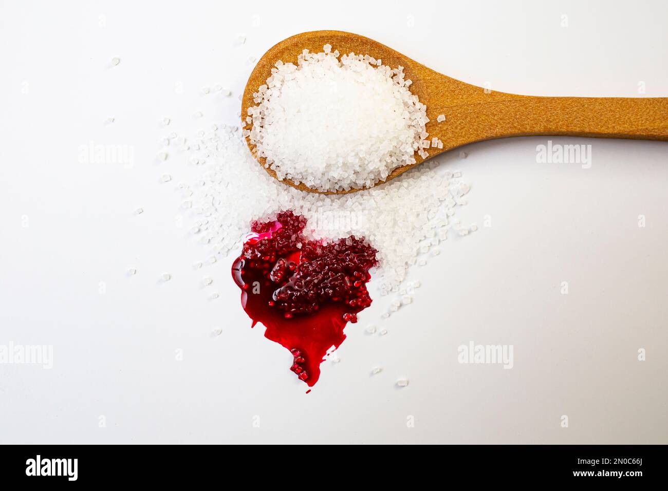 Red blood splatter mixed with sugar crystals on white background, and ...