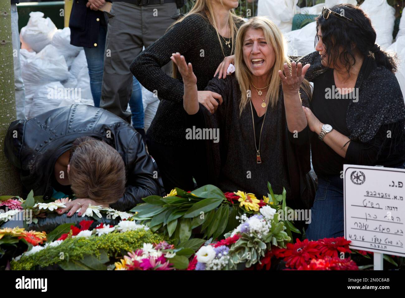 Family members mourn over the grave of Hadar Cohen, an Israeli female ...