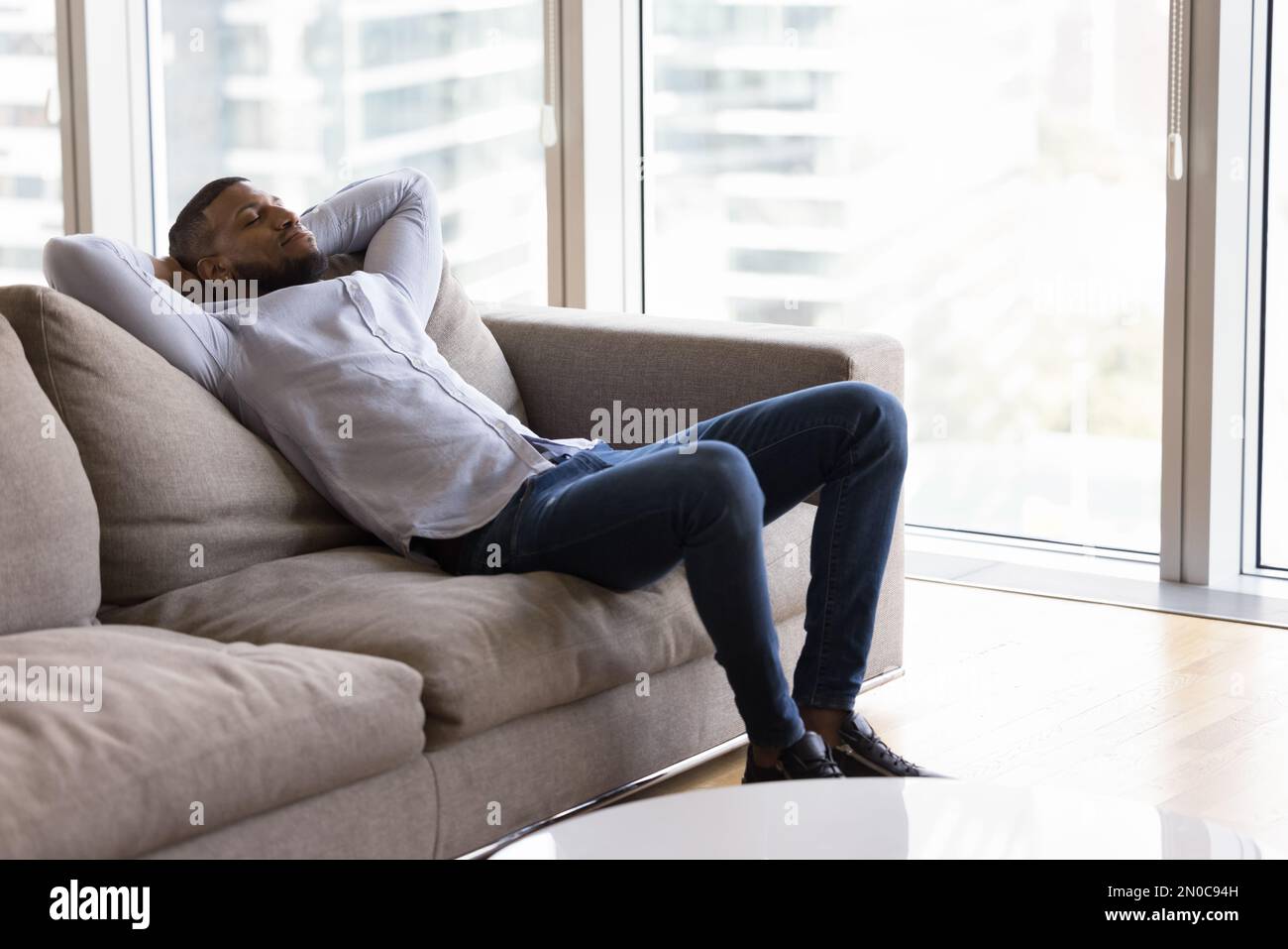 Calm sleepy young African man resting on home sofa Stock Photo - Alamy