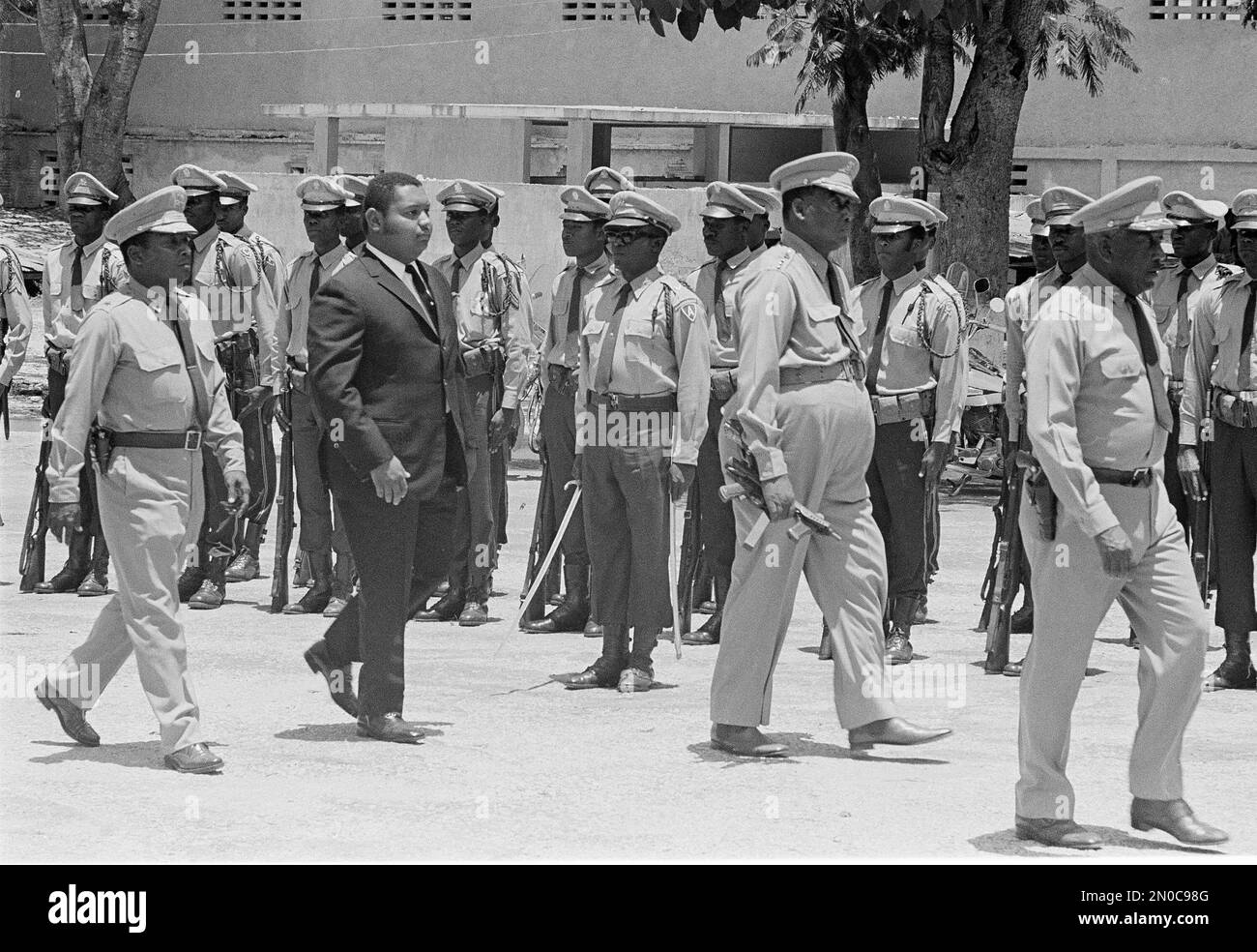 President Jean-Claude Duvalier of Haiti, dark suit, reviews troops in a ...