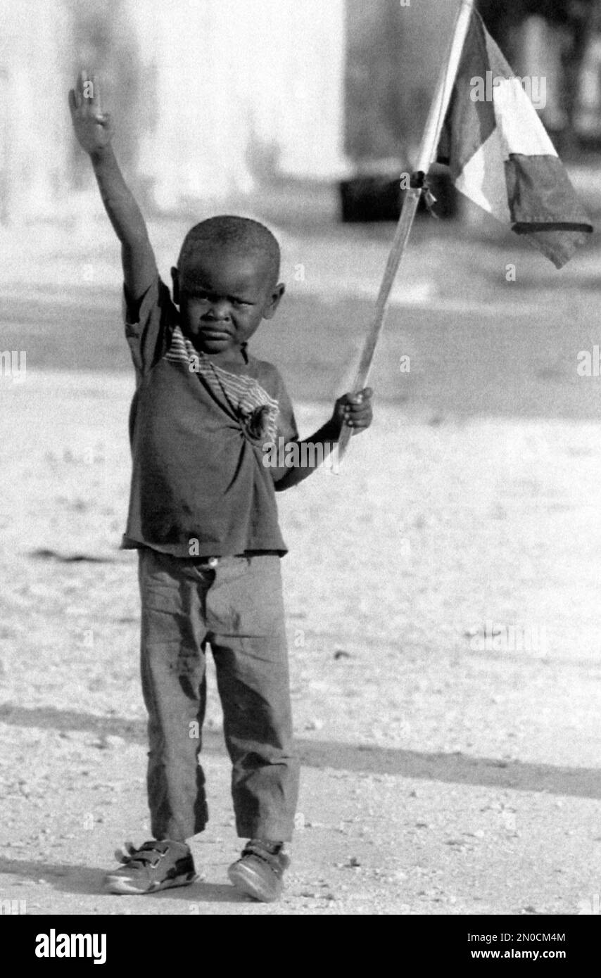 Five year old boy, Adnan, waves an Italian flag and gives a salute to ...