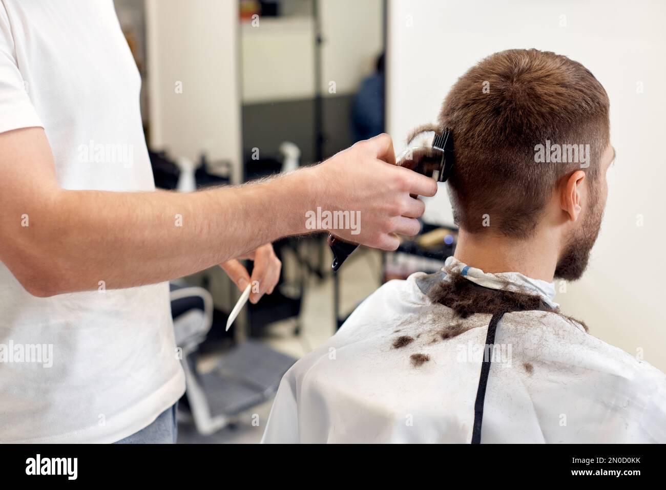 Barber trim hair with clipper on handsome bearded man Stock Photo - Alamy