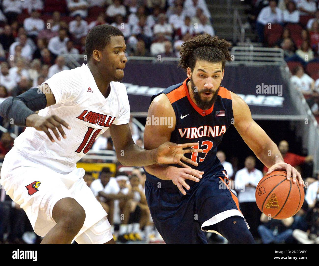 Virginia's Anthony Gill (13) drives around the defense of Louisville's ...